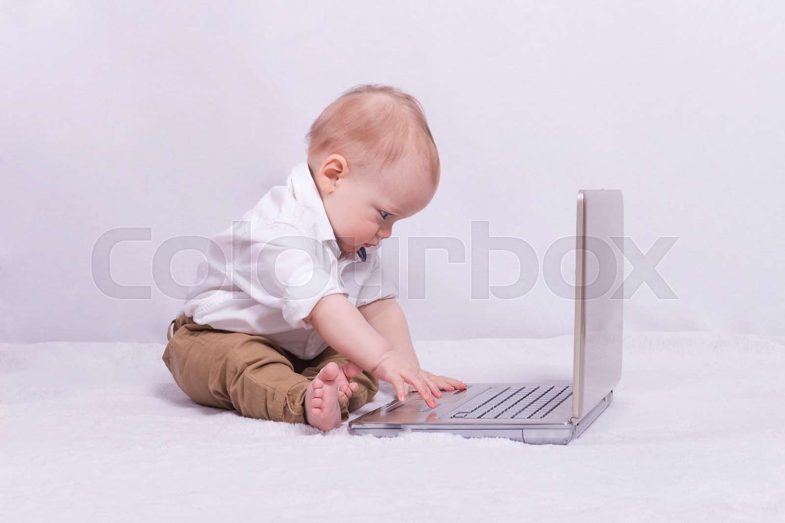 Concentrated baby boy playing in laptop. Concept of IT generation ...