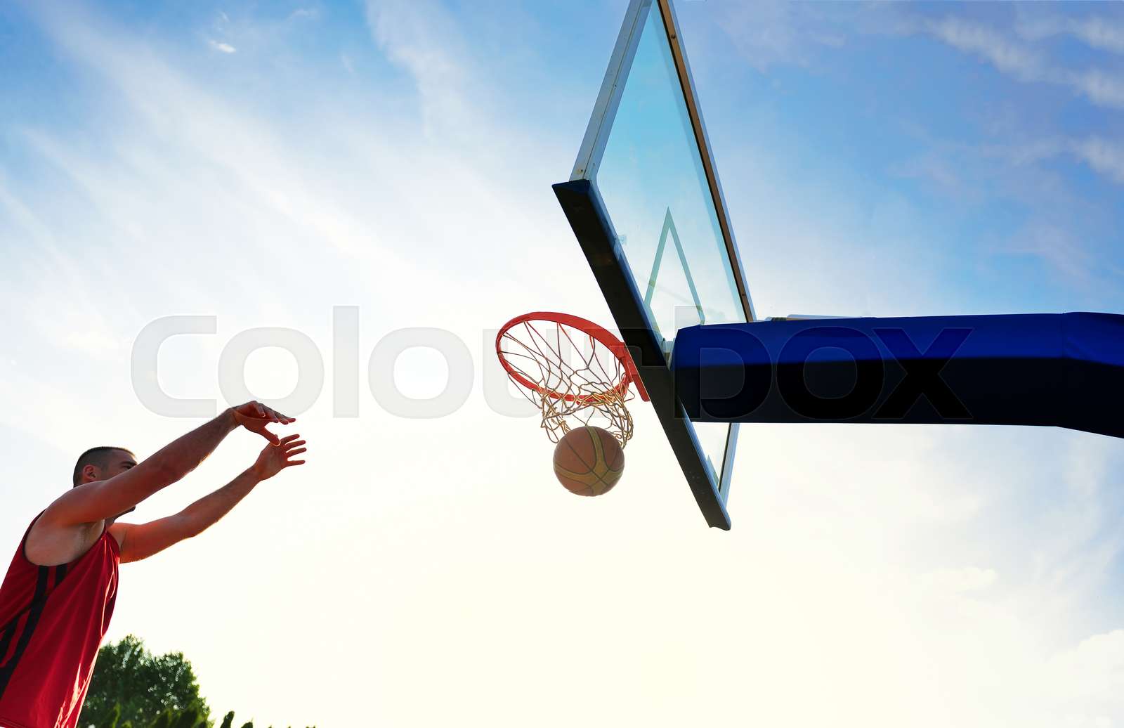 Young basketball player drives to the hoop for a high flying slam dunk ...