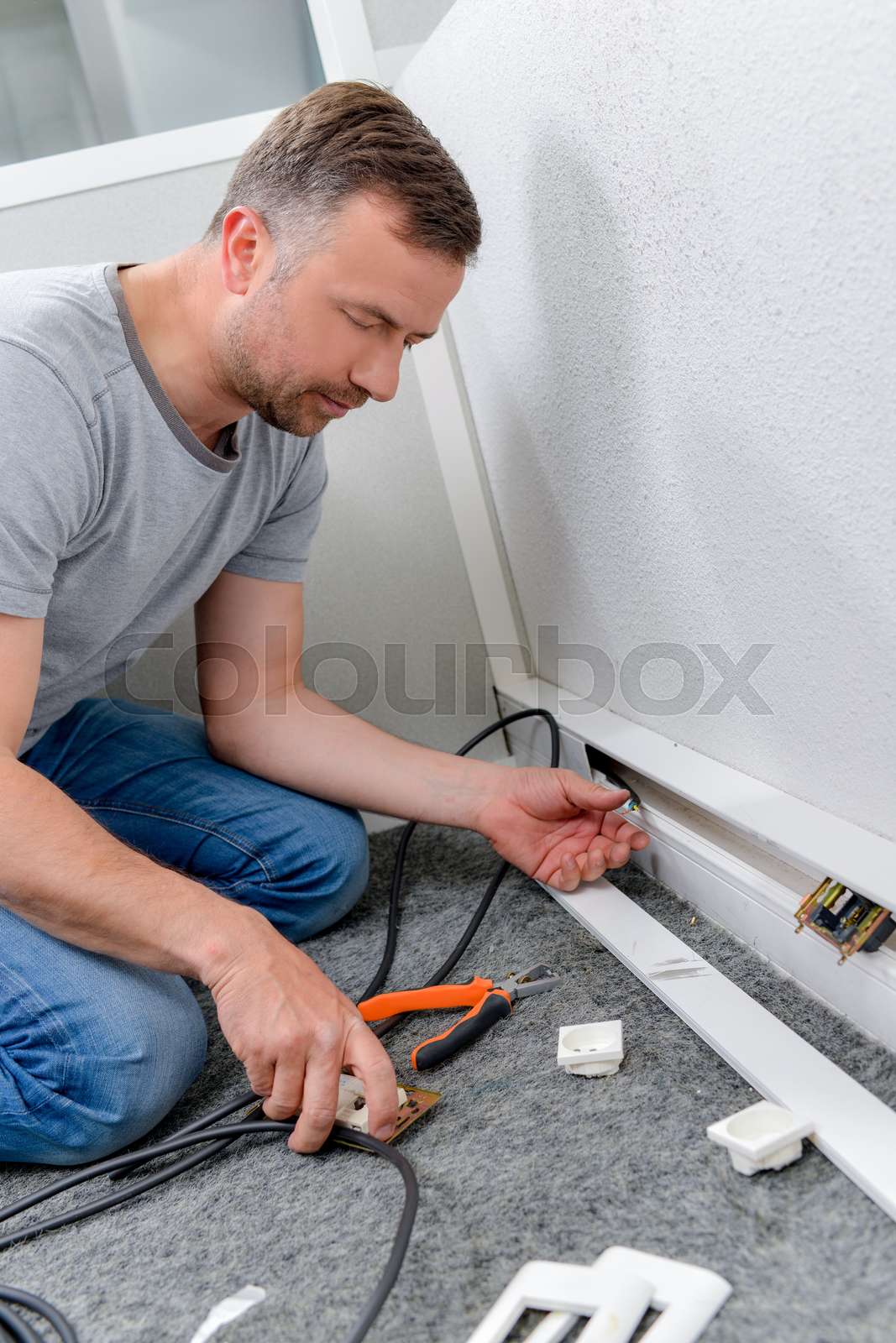 Fixing a broken electrical socket | Stock image | Colourbox