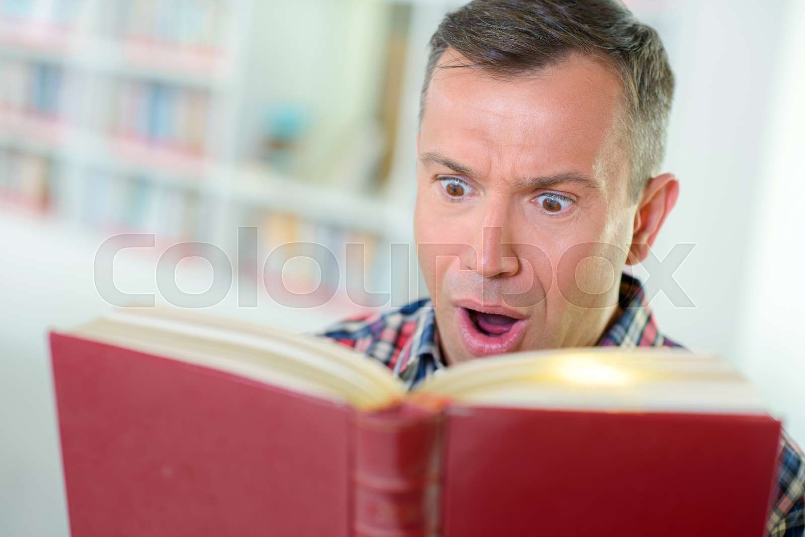 Man reading book, horrified expression | Stock image | Colourbox