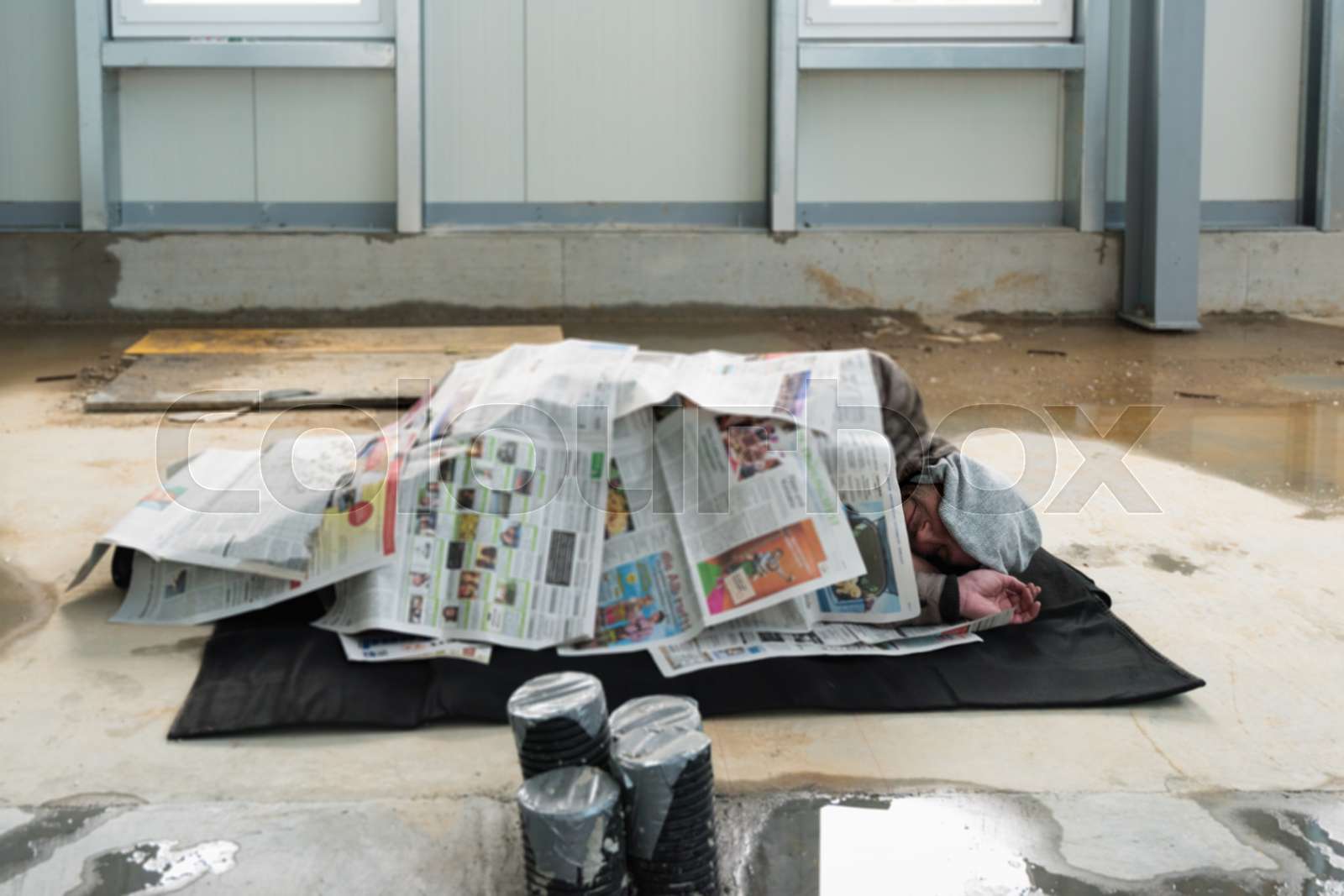 Homeless men sleeping on construction site | Stock image | Colourbox
