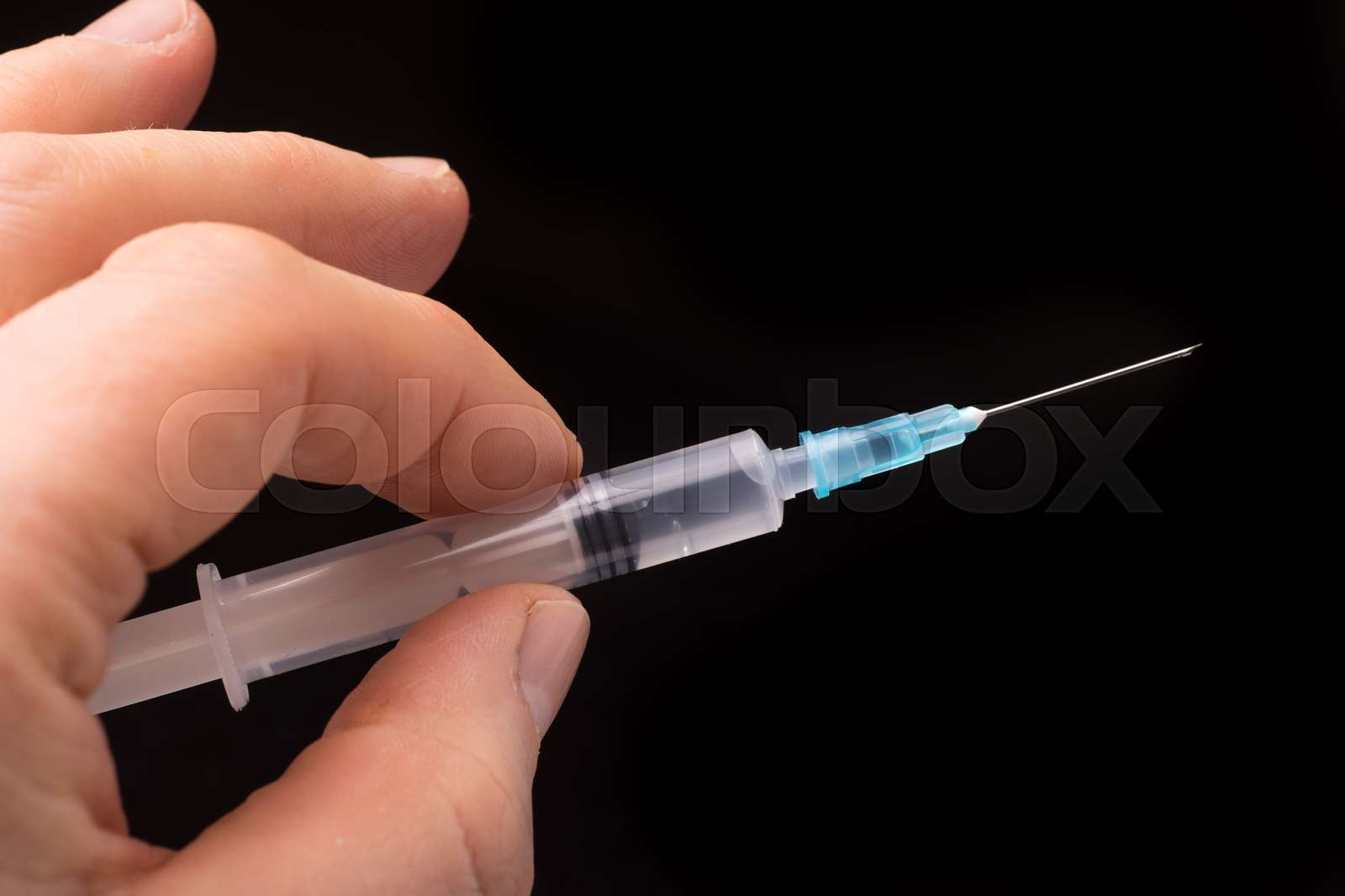 Hand holding a syringe | Stock image | Colourbox