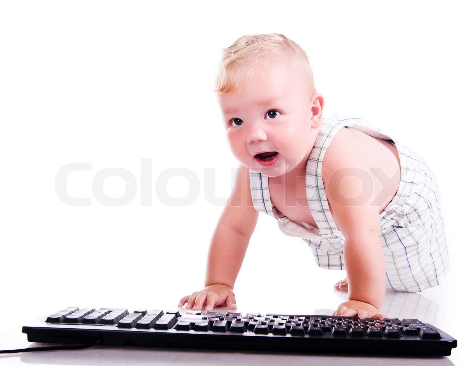 Little child holding keyboard isolated over white | Stock image | Colourbox