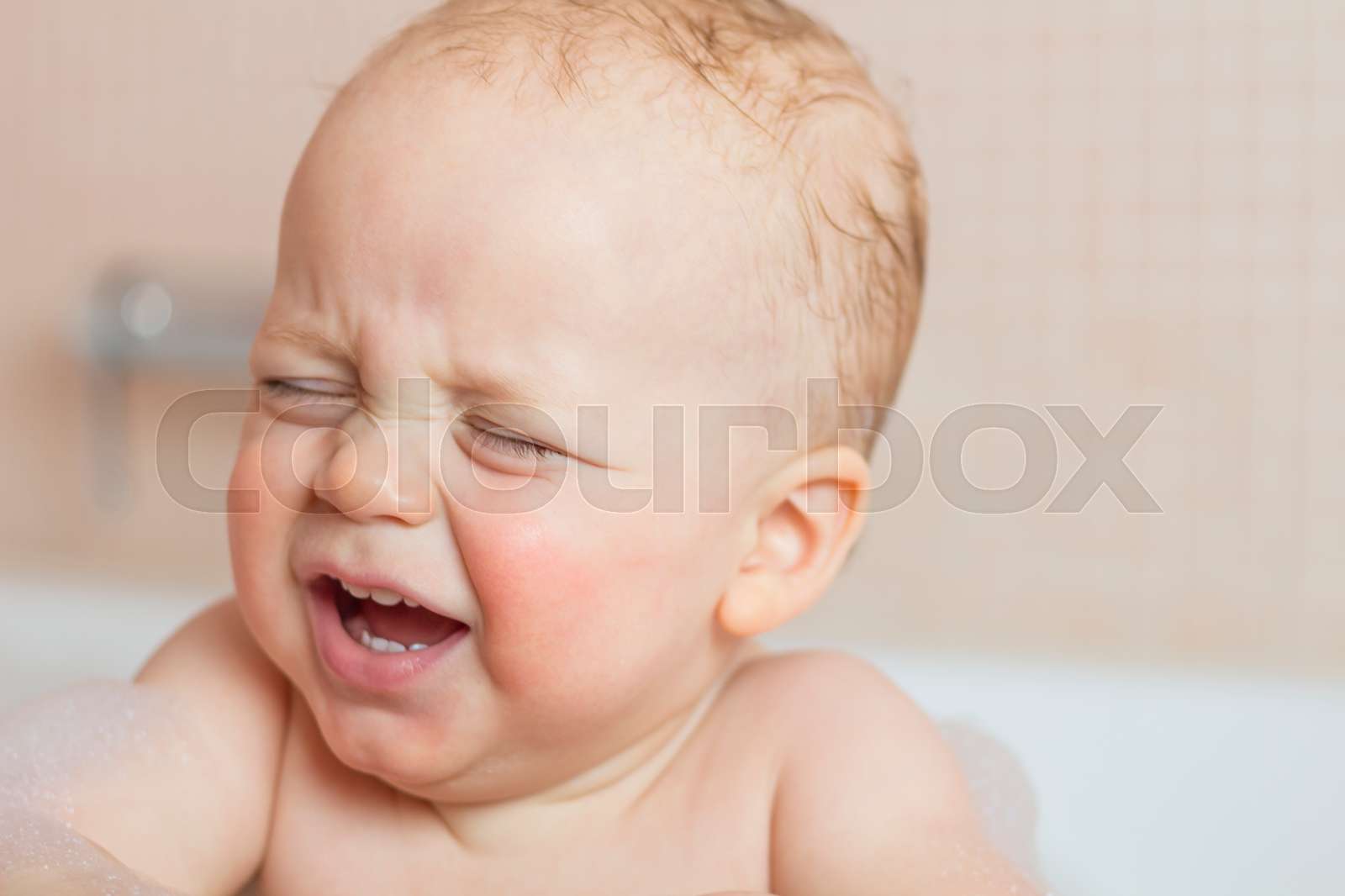 Crying baby by in a bathtub. Infant kid sreaming while taking a bath ...