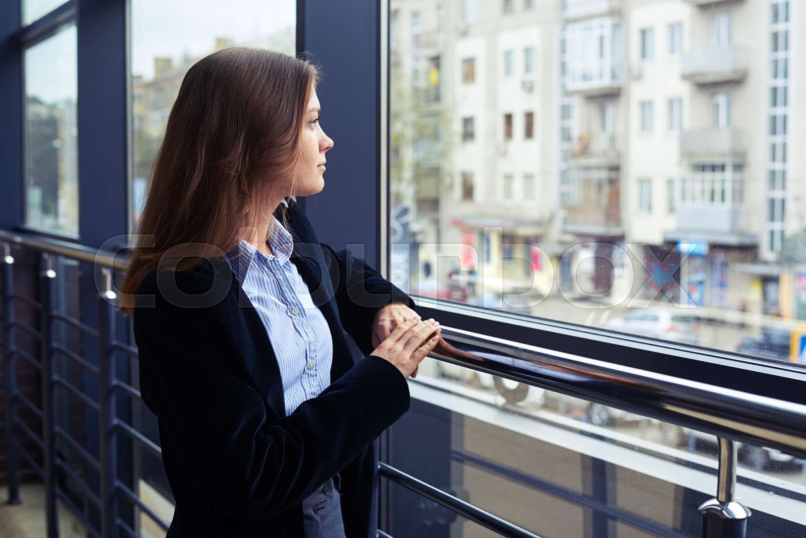 Pensive young woman looking through the window | Stock image | Colourbox