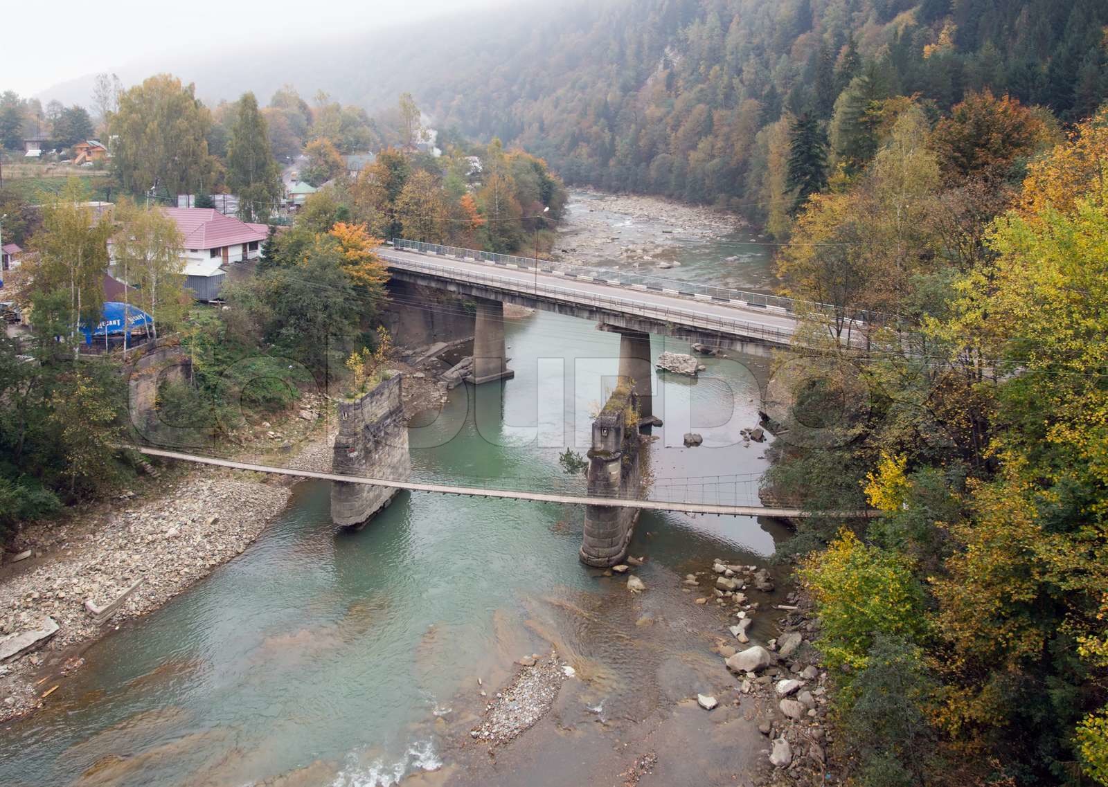 highway and pedestrian suspension bridge across mountain river (view ...