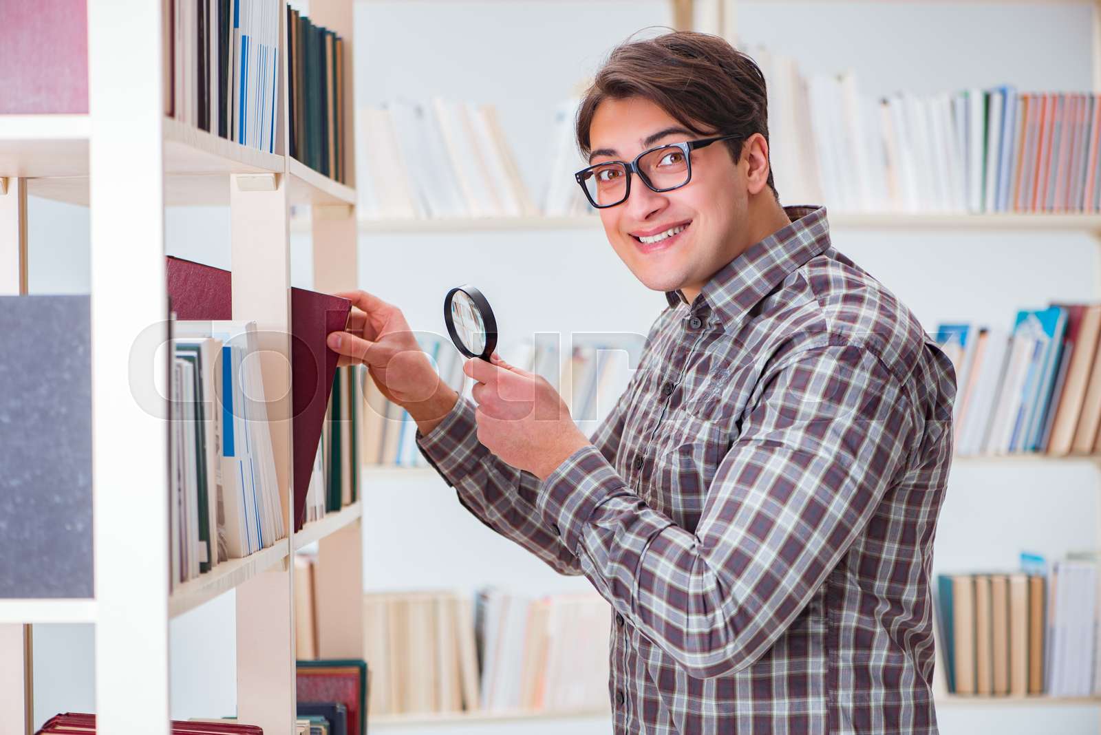 Young student looking for books in college library - Stock Image ...