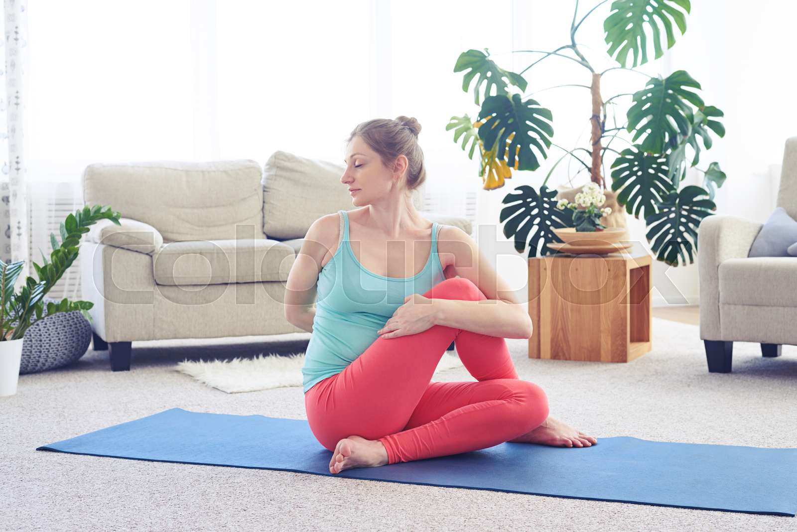 Attractive female practicing seated twist pose | Stock image | Colourbox