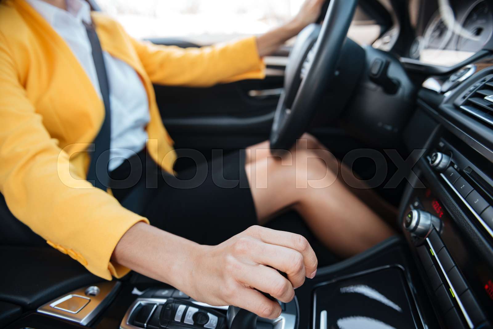 Woman shifting gears on gearbox and driving car | Stock image | Colourbox