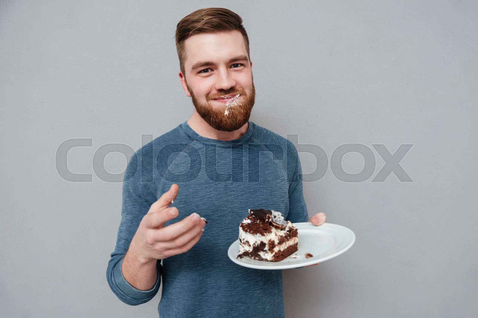 Happy smiling bearded man eating chocolate cake | Stock image | Colourbox