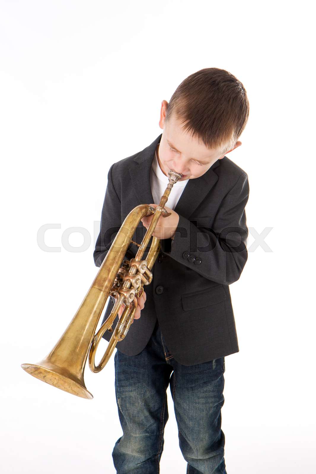 young boy blowing into a trumpet against white background | Stock image ...