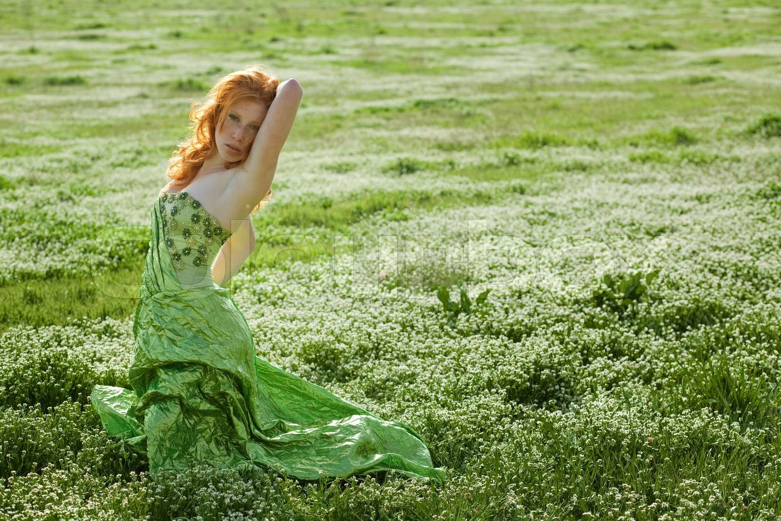 Slim young girl posing in green spring field | Stock image | Colourbox