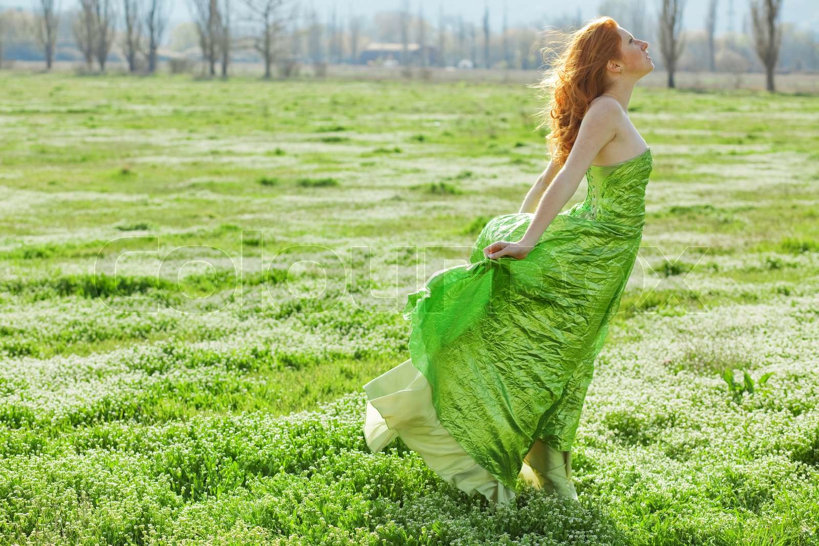 Slim young girl posing in green spring field | Stock image | Colourbox