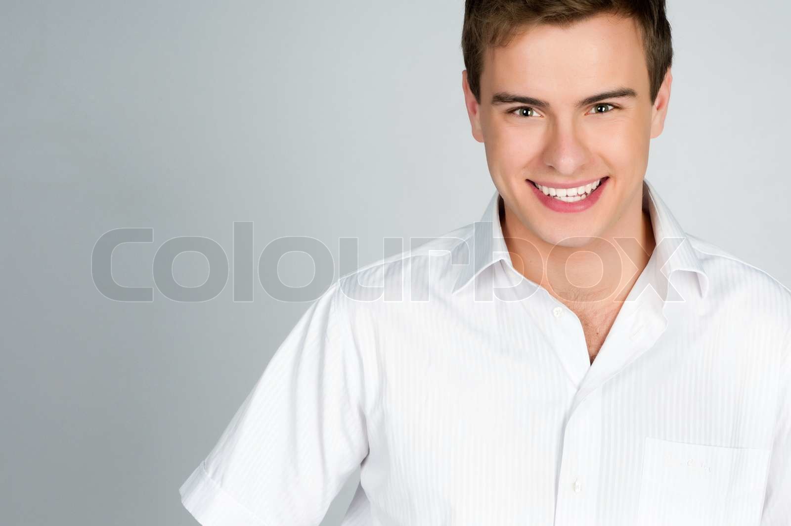 smuk ung mand smiler og kigger ind i kameraet | Stock foto | Colourbox
