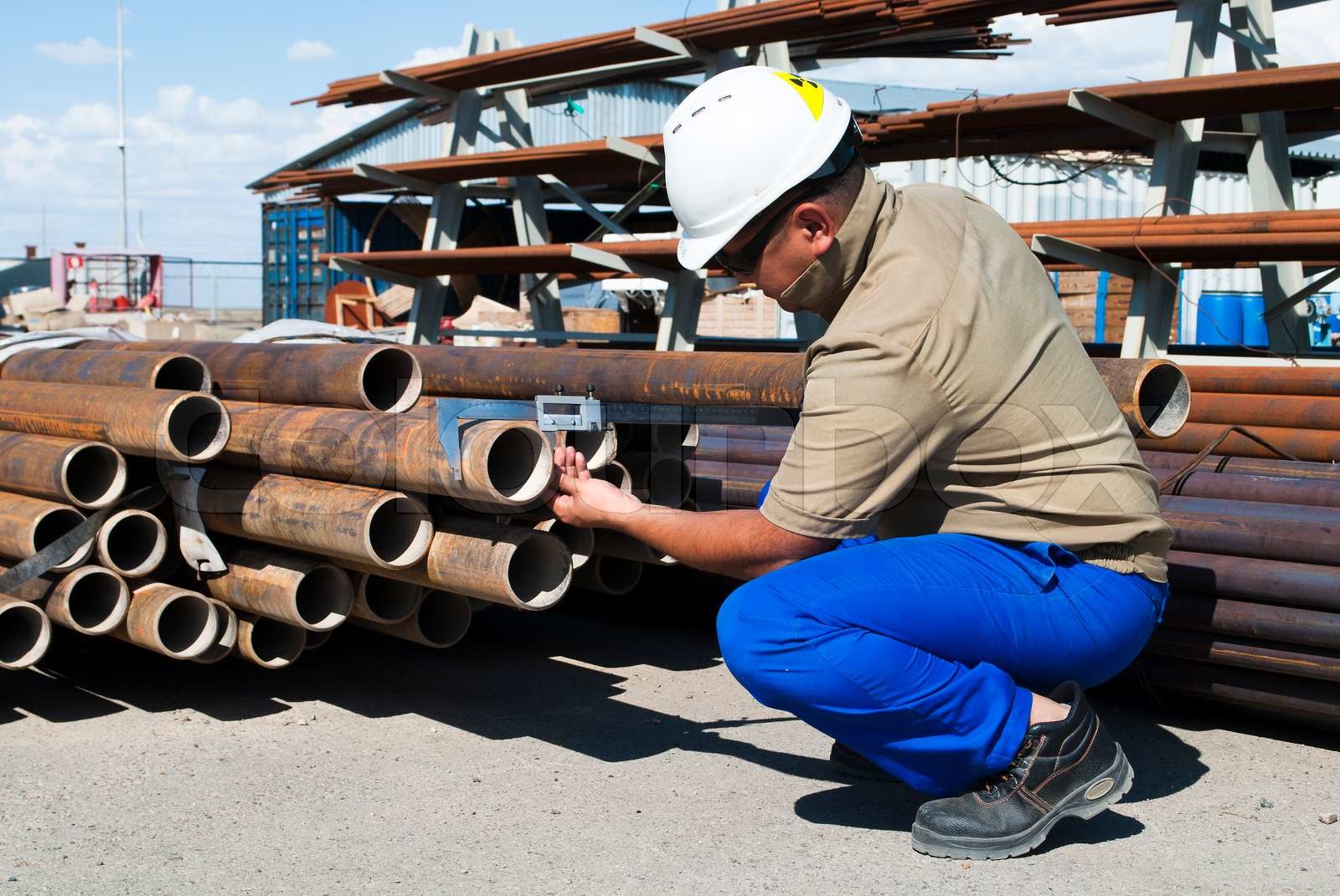 worker measures the pipes | Stock image | Colourbox