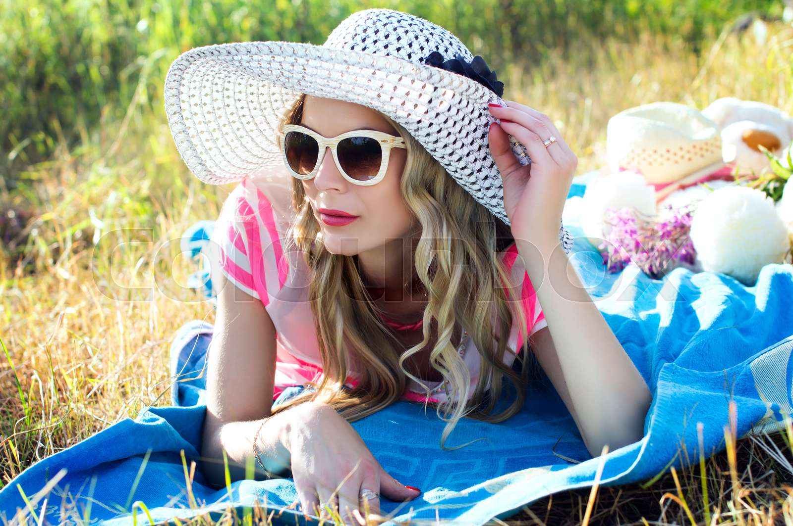 Beautiful girl sunbathing on nature in a hat | Stock image | Colourbox