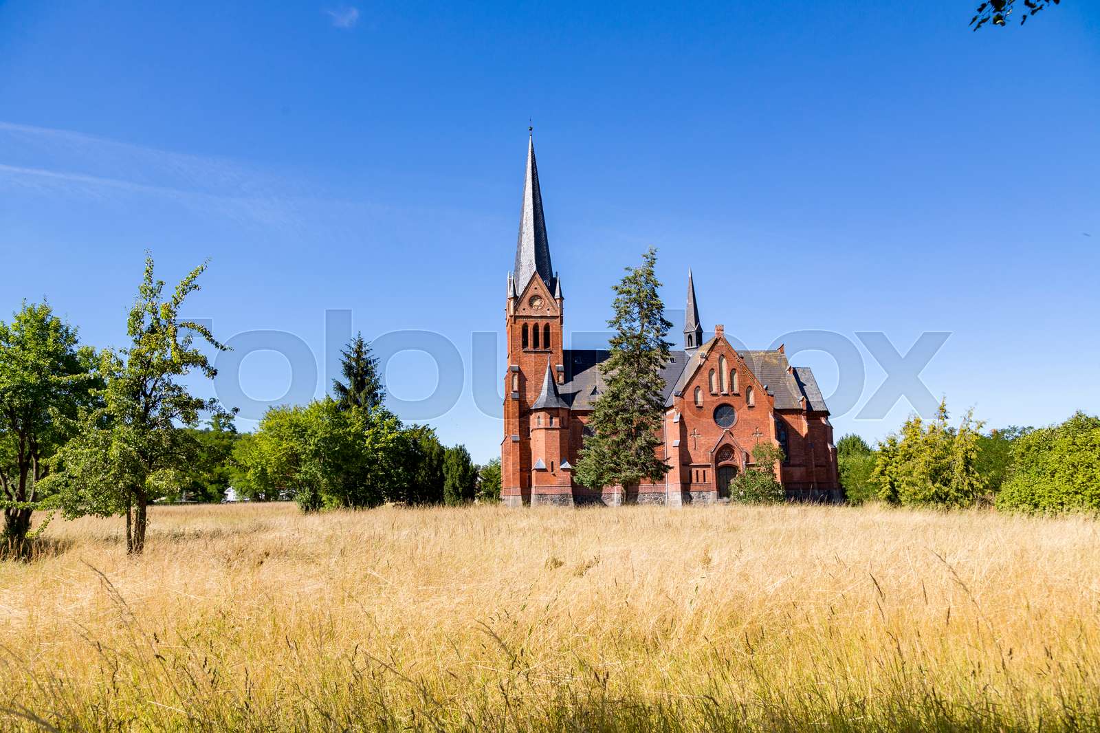 red brick church on a wild meadow | Stock Bild | Colourbox