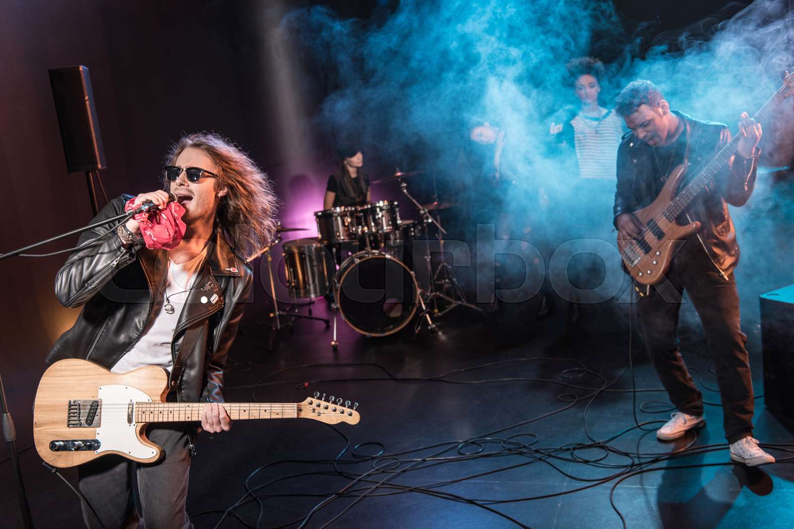 Male singer with microphone and rock and roll band performing hard rock ...