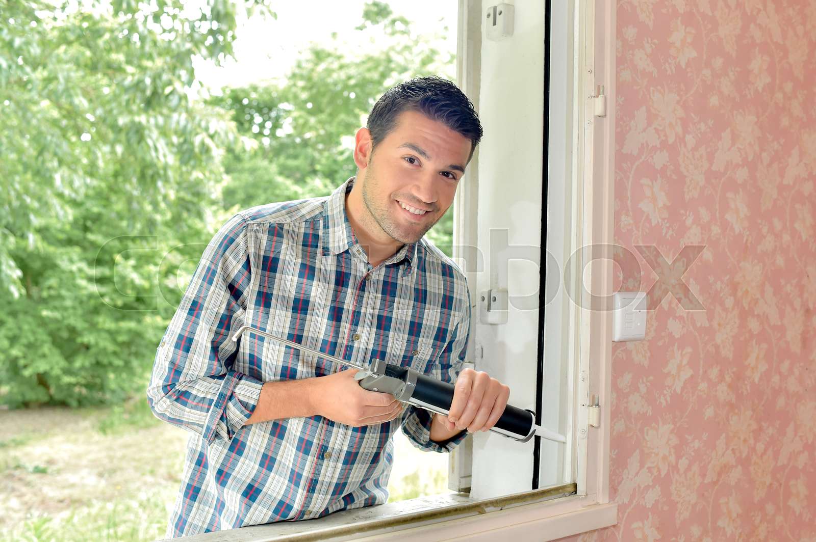 man fixing window | Stock image | Colourbox