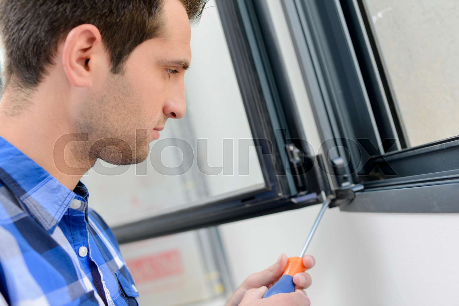 man fixing window | Stock image | Colourbox