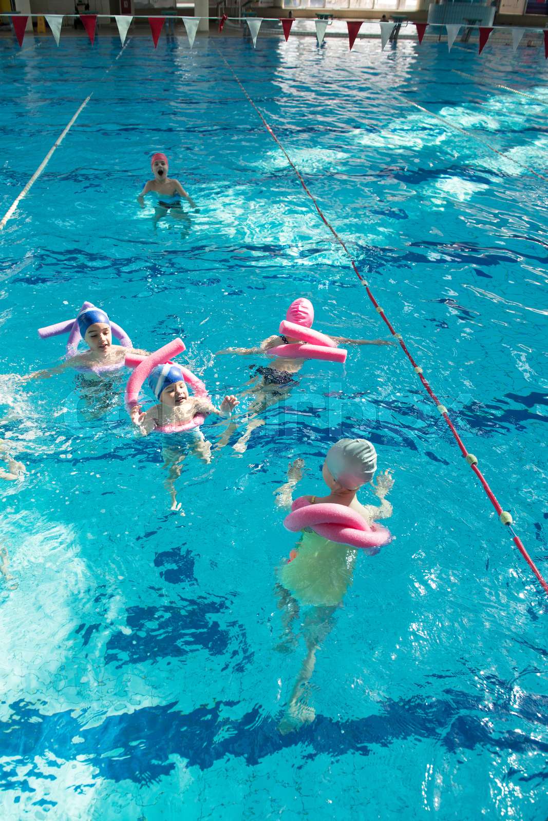 happy children kids group at swimming pool class learning to swim ...