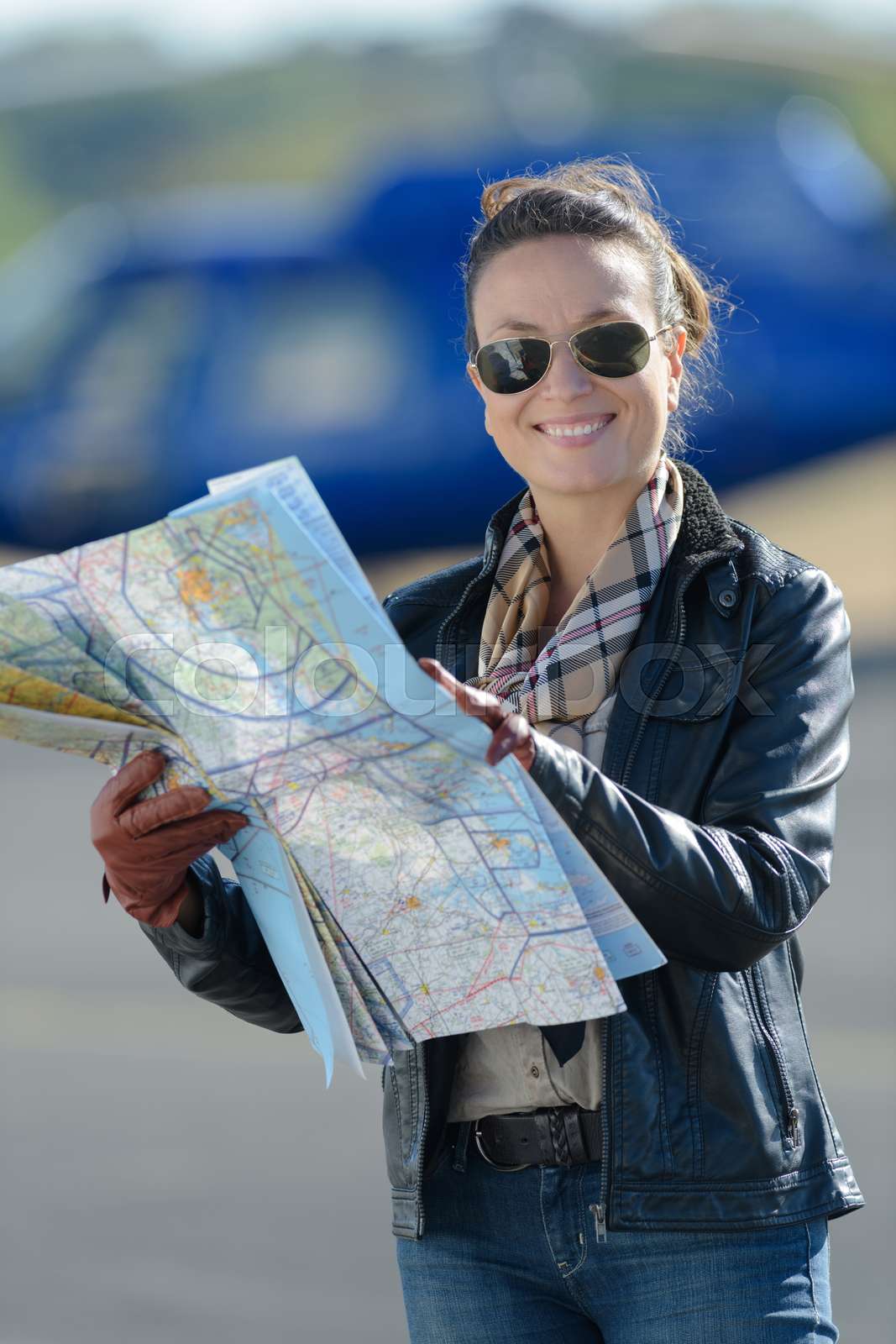 female pilot with map next to helicopter | Stock image | Colourbox