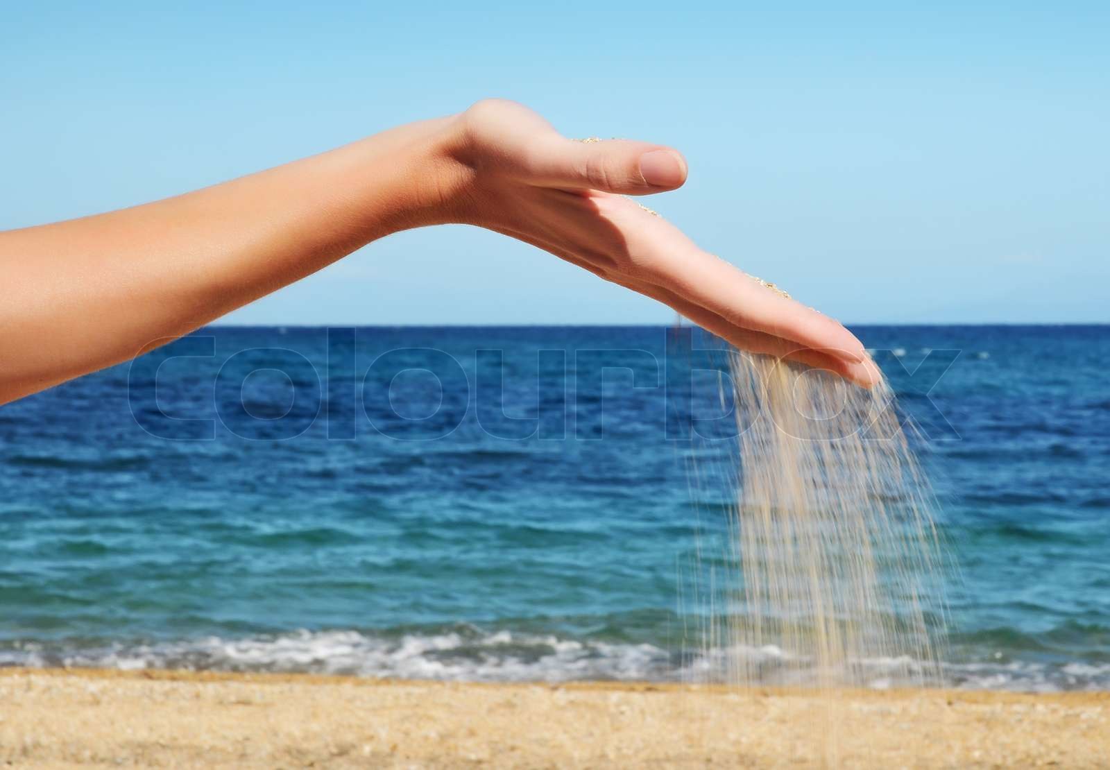 Sand falling from the woman's hand | Stock image | Colourbox