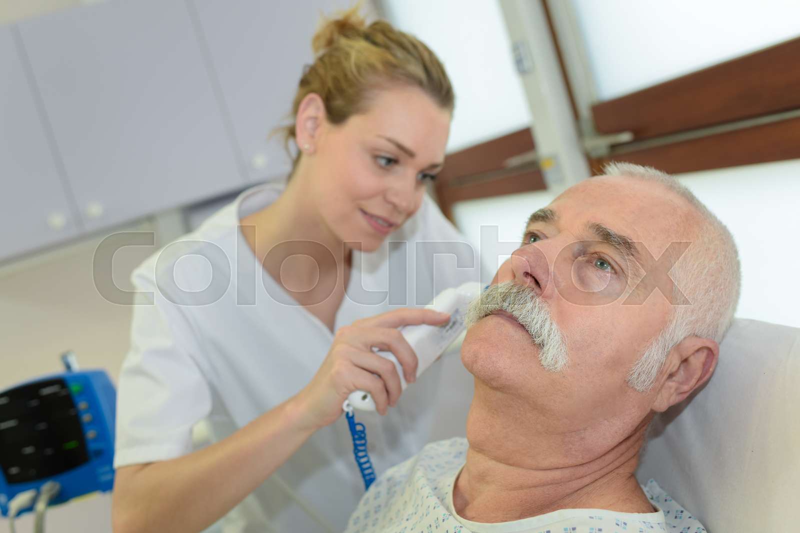 nurse shaving senior man in hospital room | Stock image | Colourbox
