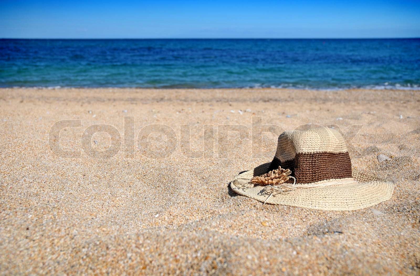 Stråhat liggende i sandet på stranden | Stock foto | Colourbox