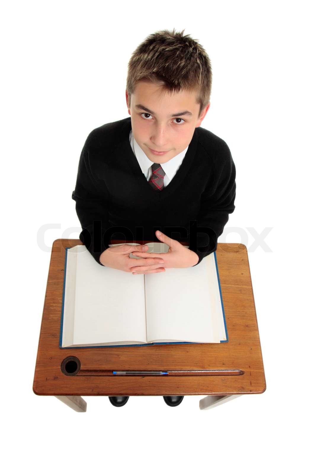 School boy sitting down at a school desk with open book | Stock image ...