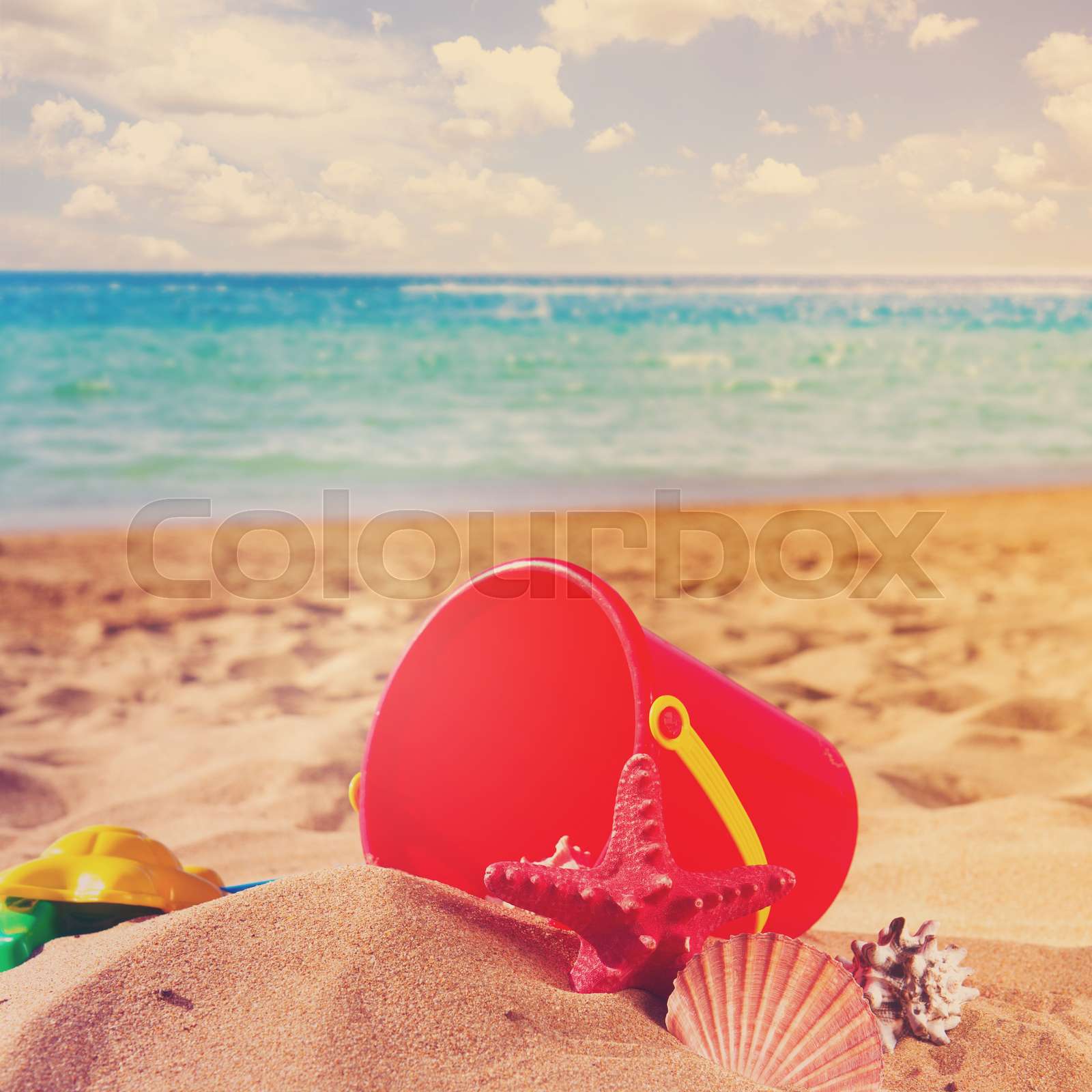 bucket with seshells in sand on sea shore | Stock image | Colourbox