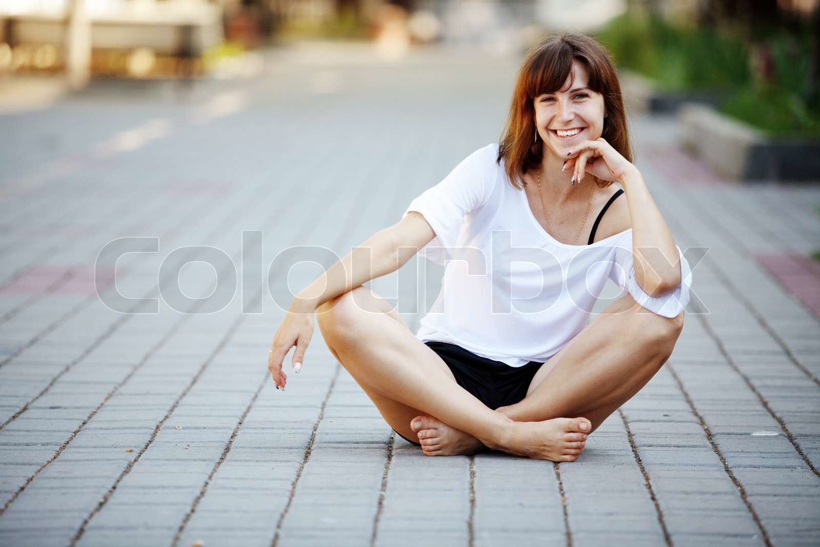 Junge barfuß Mädchen sitzen auf dem Asphalt in den Park | Stock Bild ...