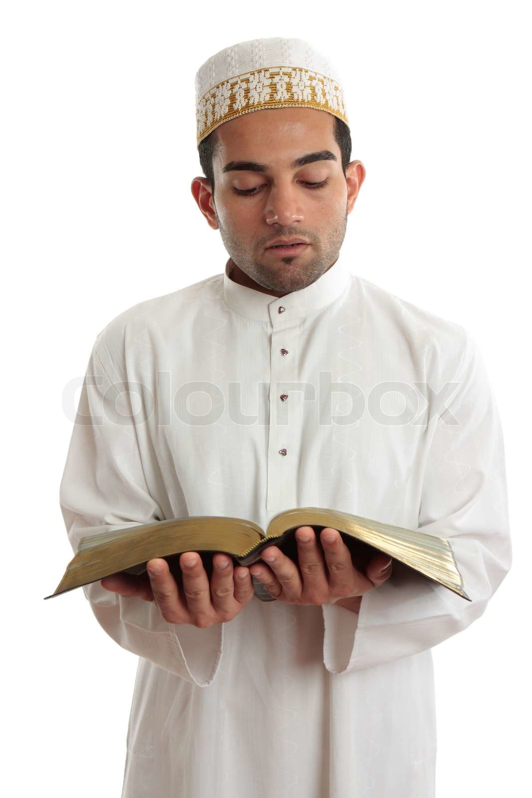 Man wearing cultural clothing is reading or studying a religious holy ...