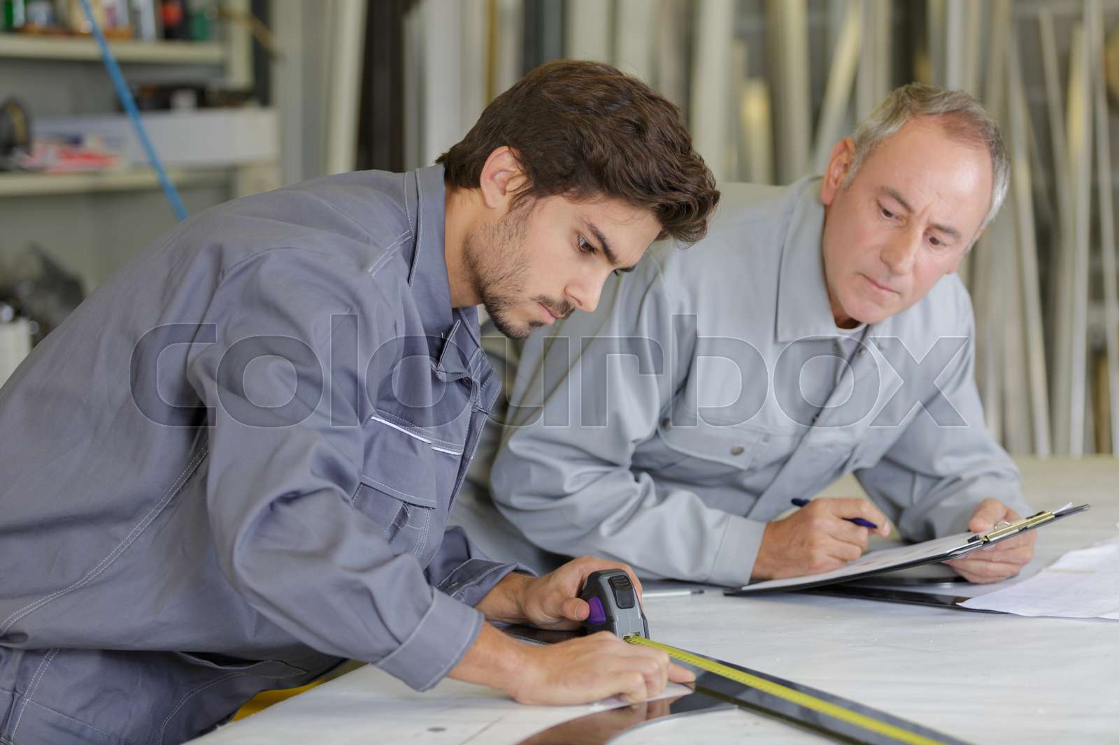 Man using tape measure, older man watching | Stock image | Colourbox