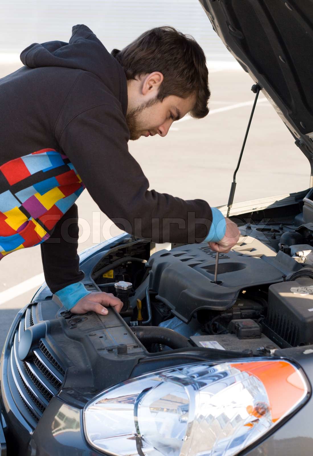 Car driver examining the car's engine on a parking | Stock image ...