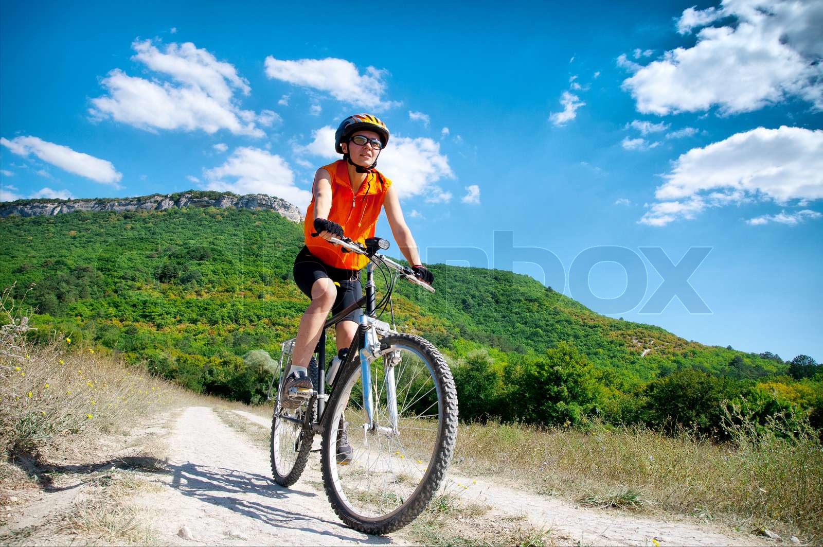 young athletic girl rides a bicycle on a mountain road | Stock image ...