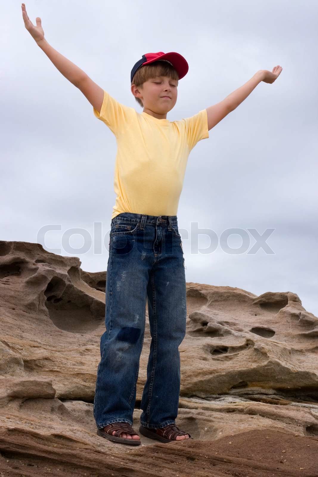 Kind mit ausgestreckten Armen verehren oder beten | Stock Bild | Colourbox