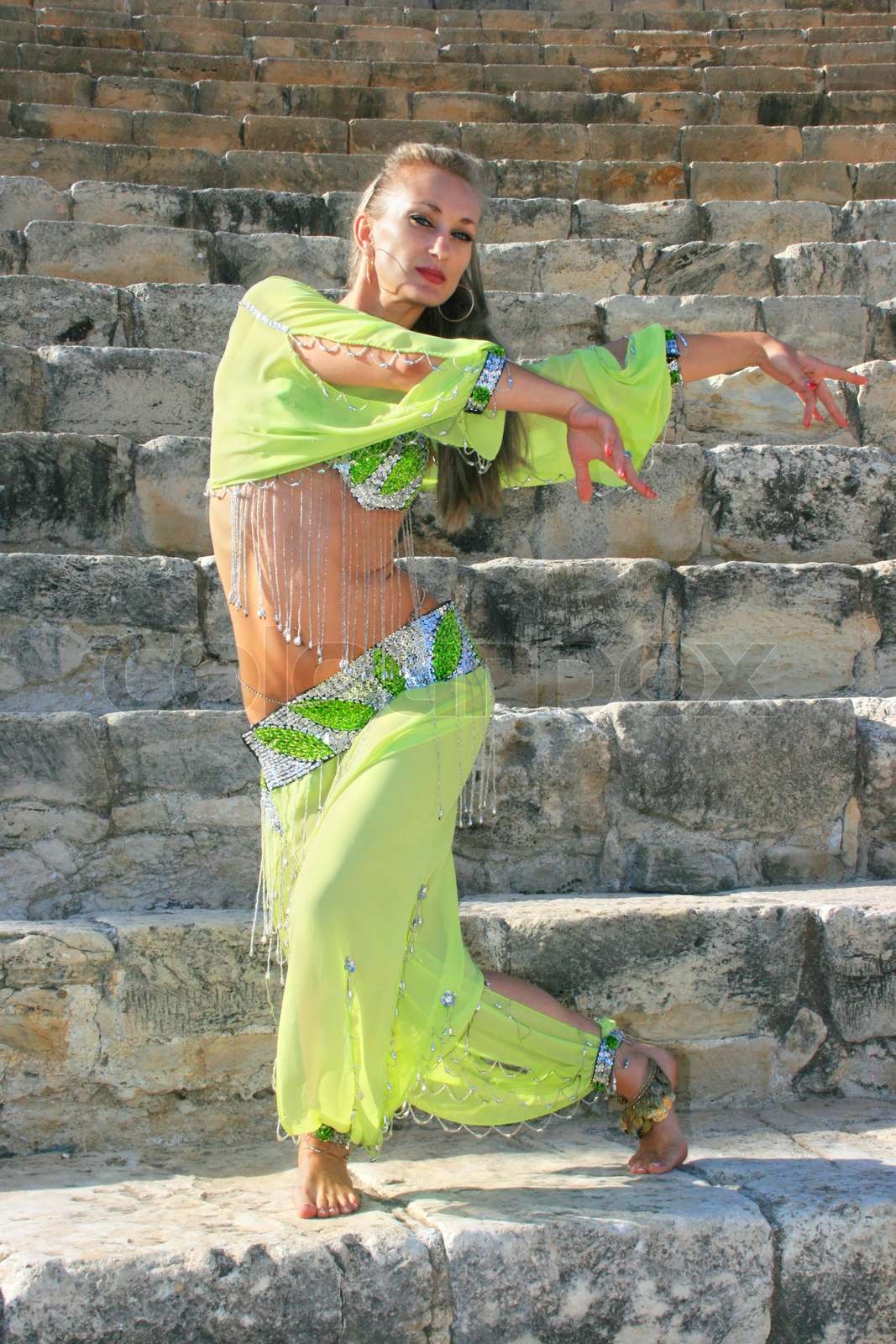 Beautiful belly dancer in green on the ancient stairs of Kourion ...