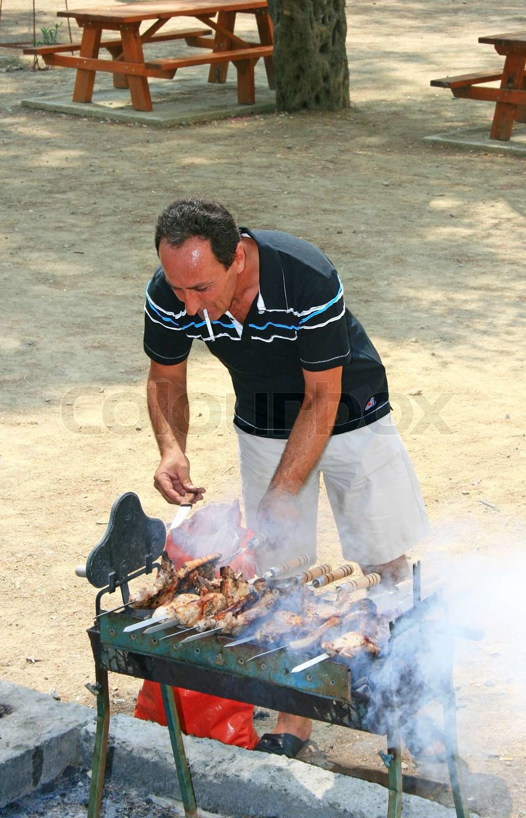 Man roasted barbecue on the charcoal | Stock image | Colourbox