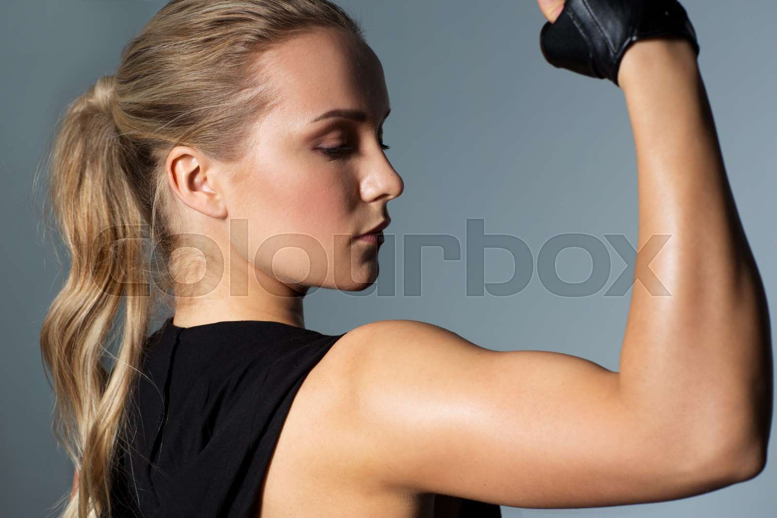 close up of woman posing and showing biceps in gym | Stock image ...