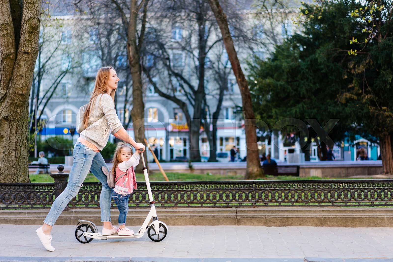 Mom and little daughter on a scooter | Stock image | Colourbox