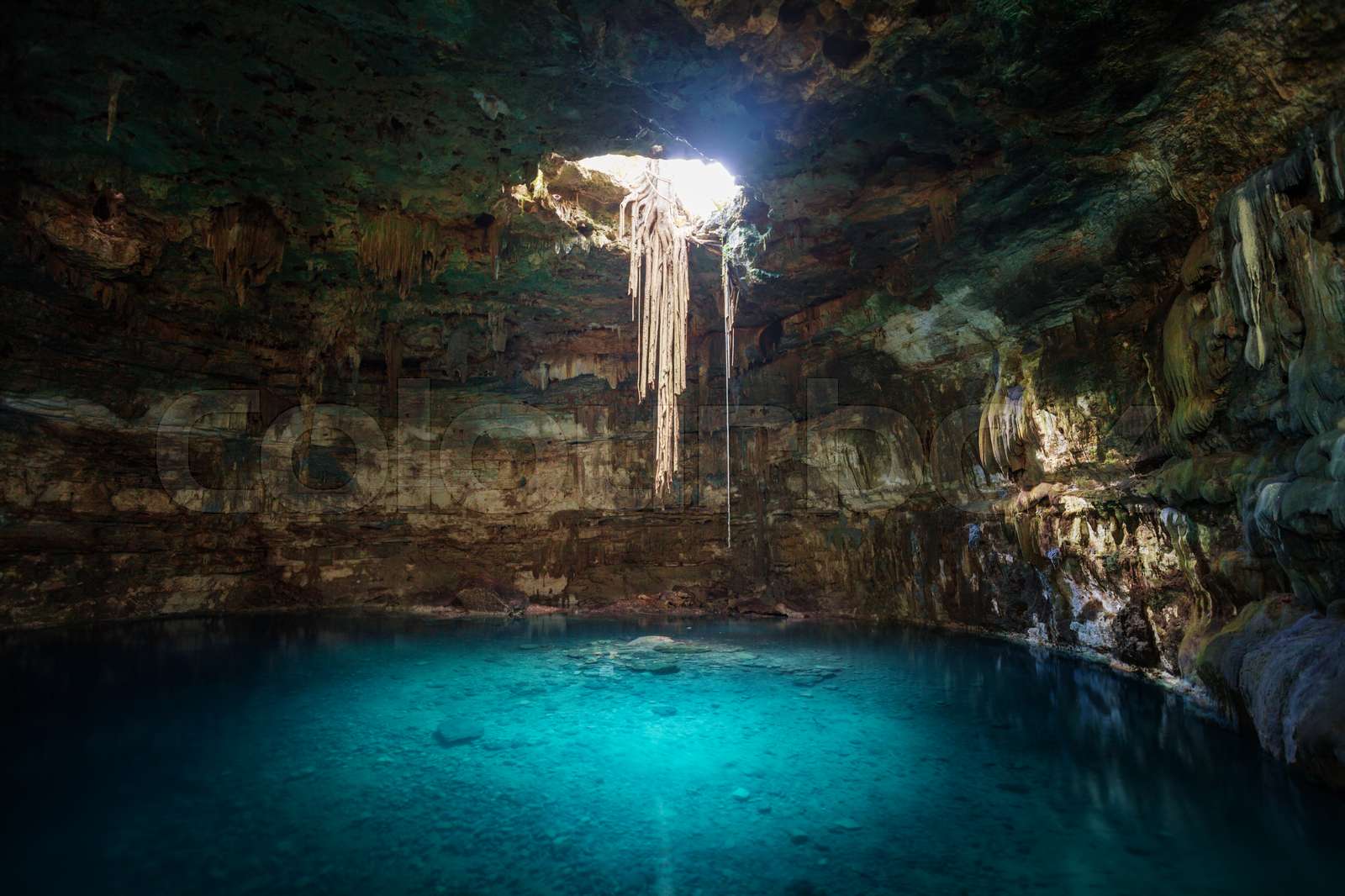 Sunbeams penetrating in opening of Blue cenote | Stock image | Colourbox