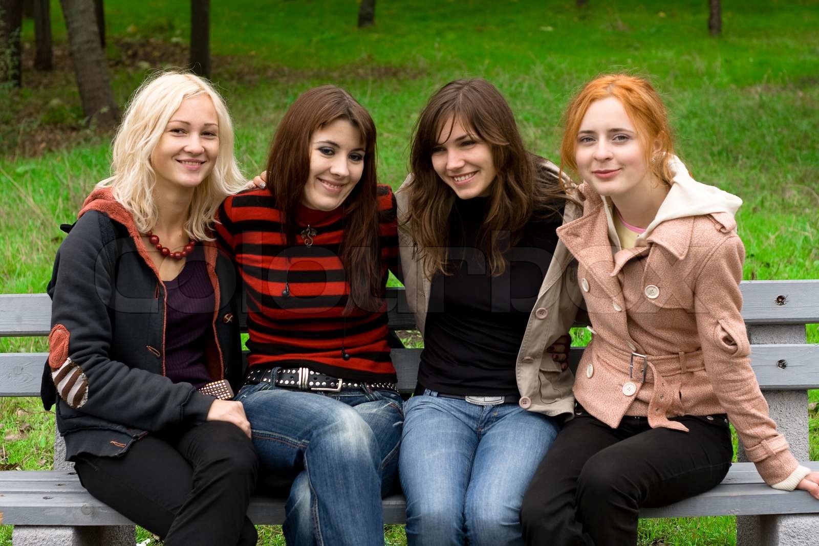 Girls resting together on a park bench | Stock image | Colourbox