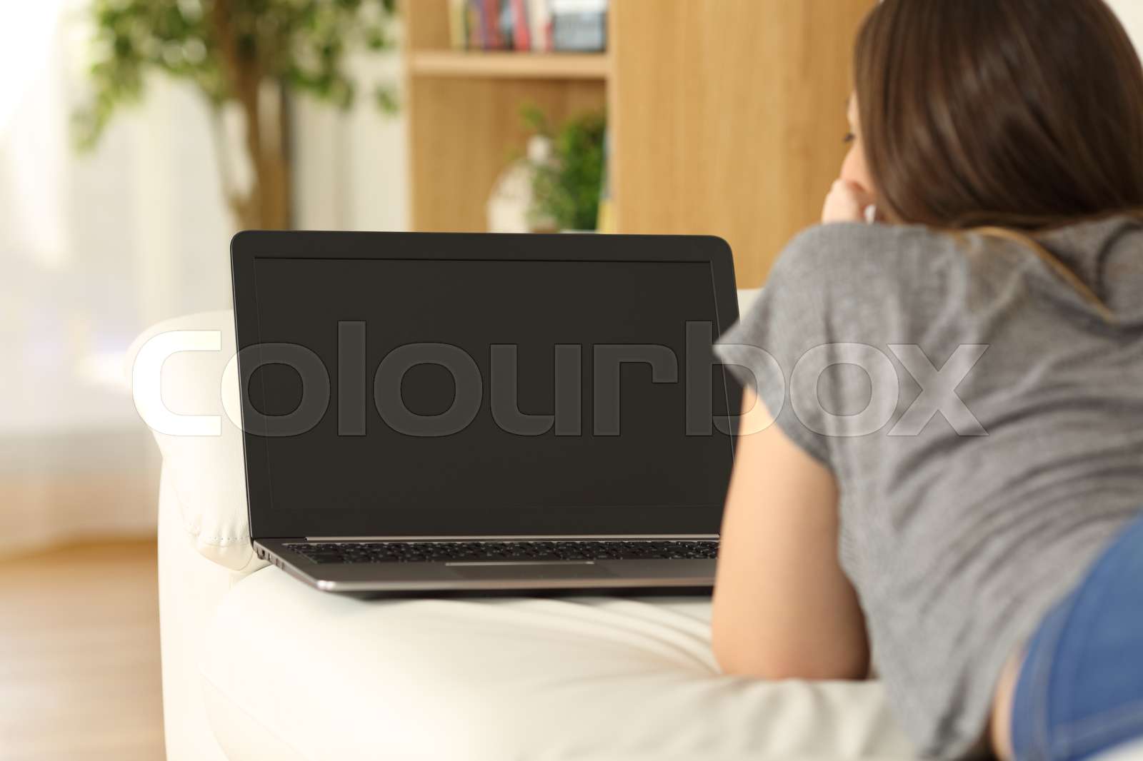 Girl watching media in a laptop showing screen | Stock image | Colourbox
