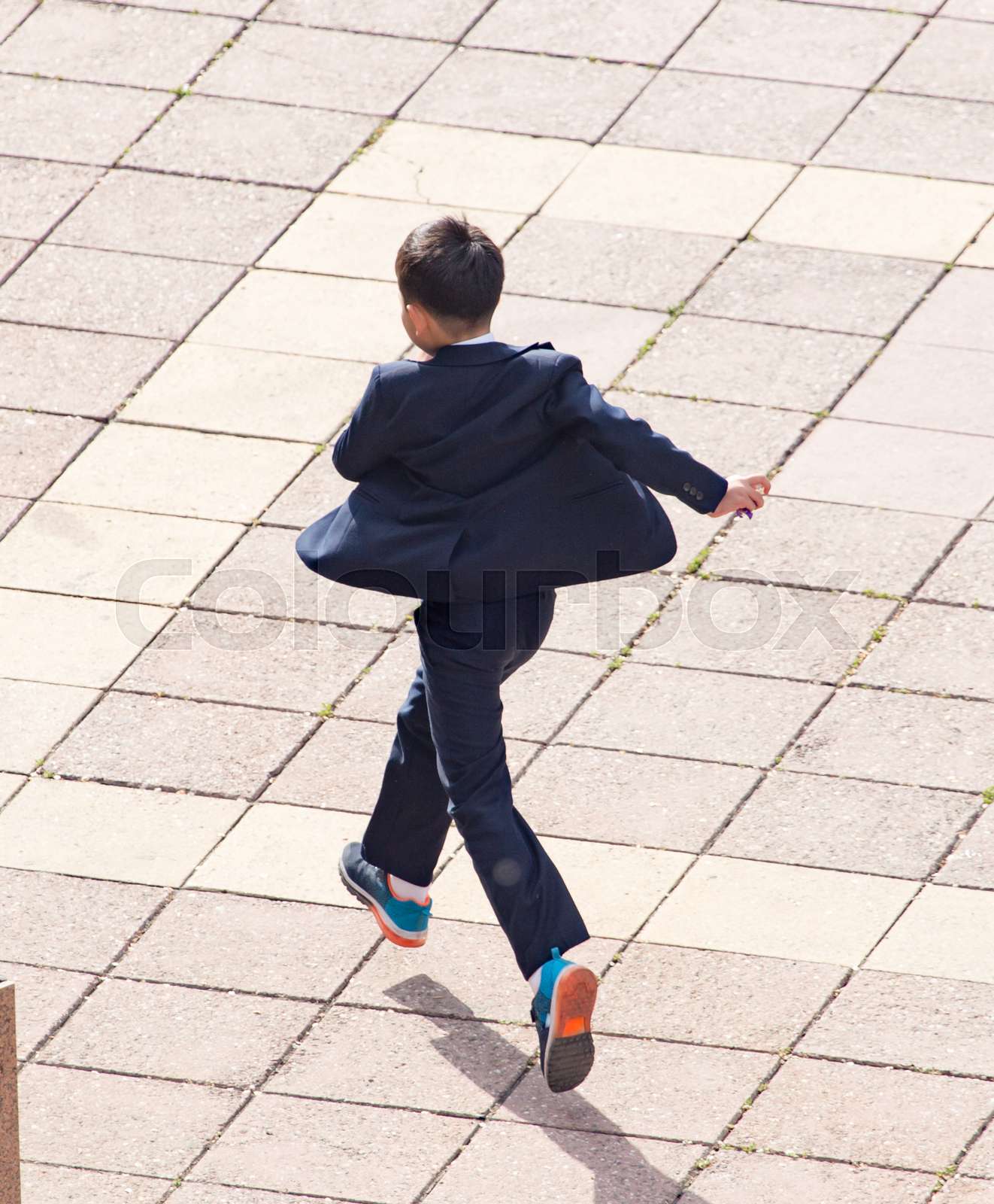 The boy runs along the pavement | Stock image | Colourbox
