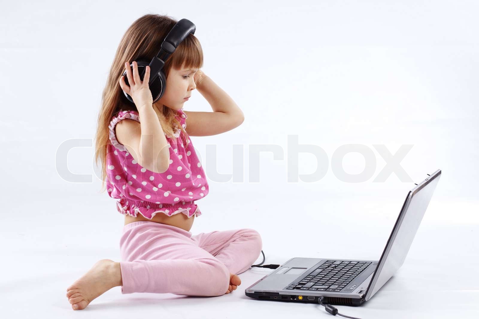 Portræt af sjove moderne barn, der leger med computer og lytte til ...