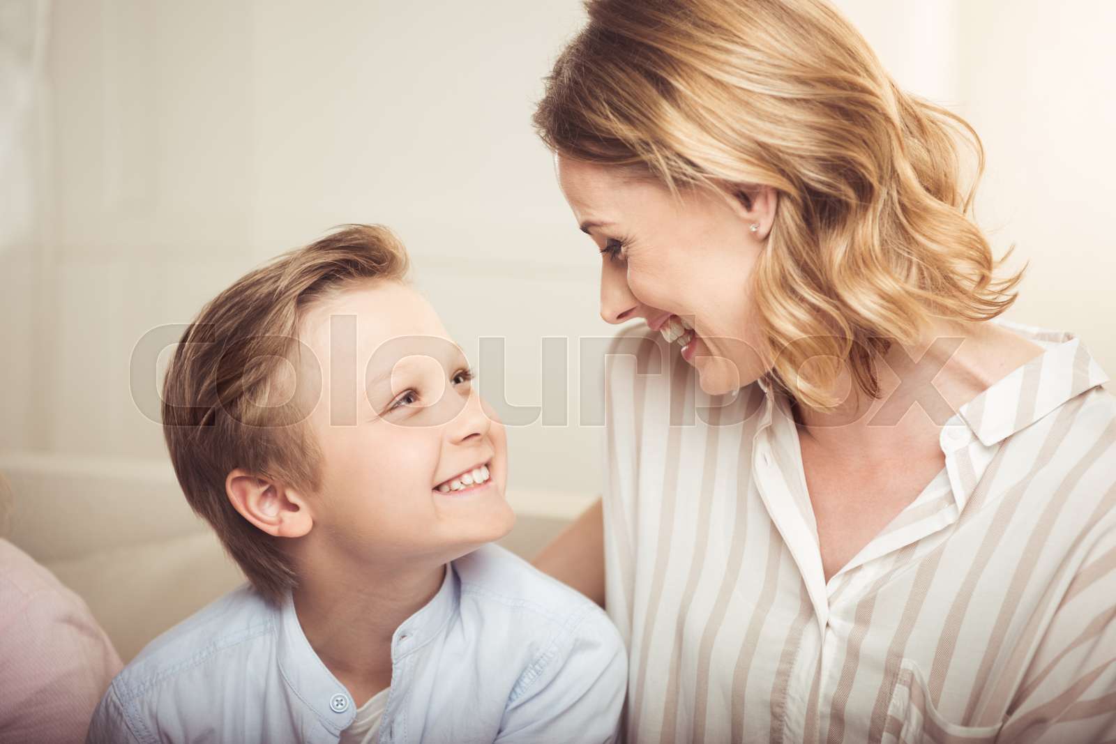 Happy mother and adorable little son smiling each other at home | Stock ...
