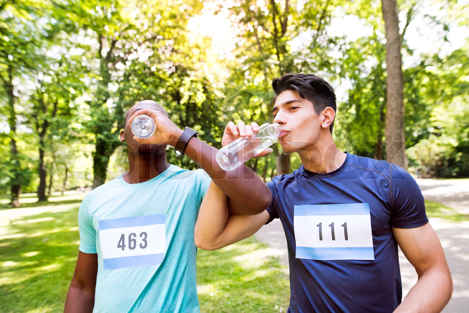Two young athletes prepared for run, drinking water. | Stock image ...