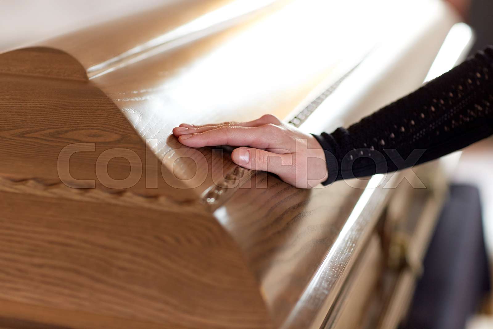 woman hand on coffin lid at funeral in church | Stock image | Colourbox