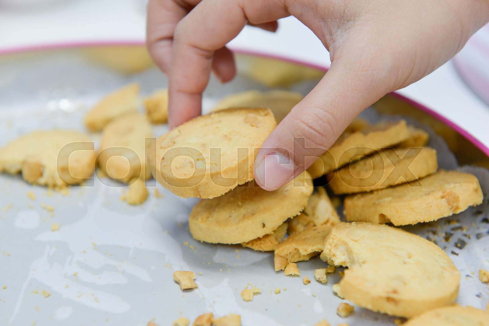 Woman hand is picking the cookie | Stock image | Colourbox